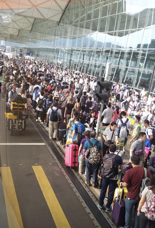 Passengers queue in long line outside Airport Terminal 1 - Dimsum Daily