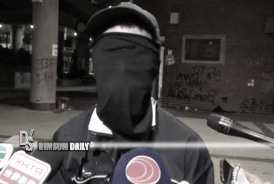 A protester from PolyU appears to speak to media reporters and ...