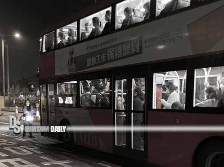 Woman stands in front of KMB bus after passengers standing in front ...