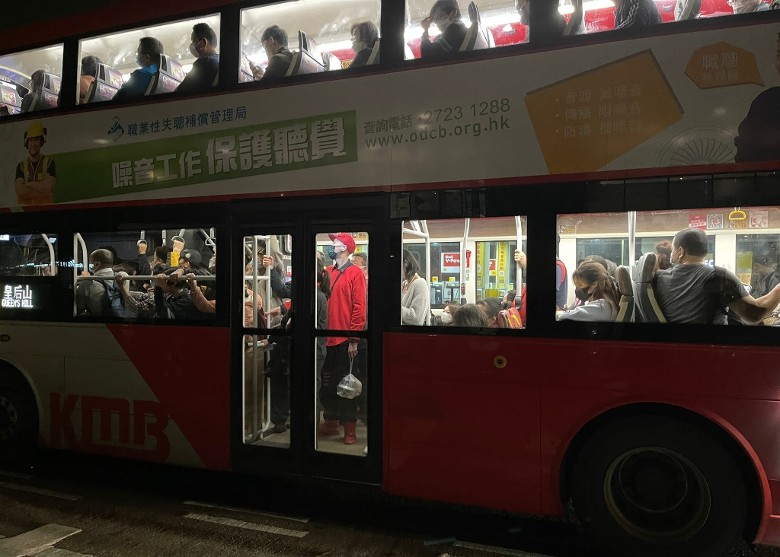 Woman stands in front of KMB bus after passengers standing in front ...