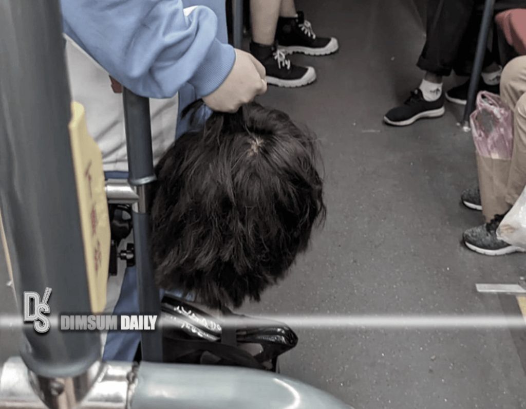 Female student calmly holds mannequin head while taking the bus ...