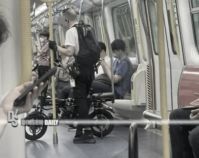 Man in military attire rides MTR train with electric bike - Dimsum Daily