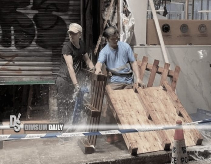 Maintenance workers use cardboard to block burst water column in ...